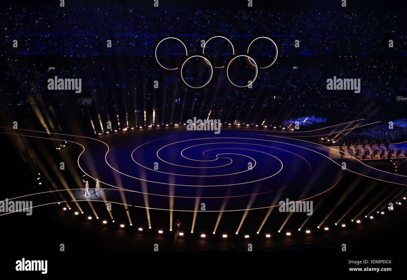 The Olympic flame is carried around the stage during Opening Ceremony ...