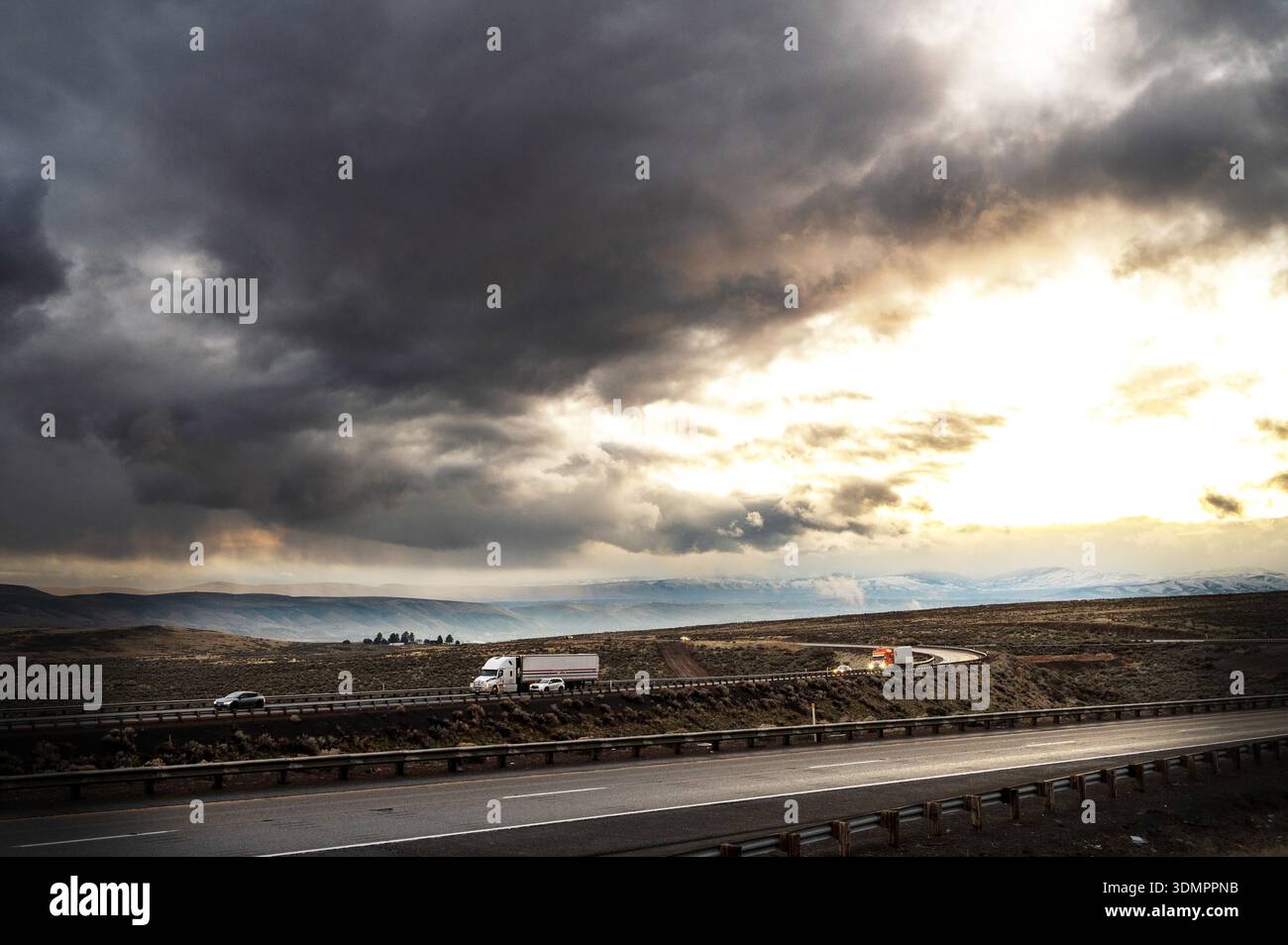 Cars and semi tractor transport trucks travel through a severe storm ...