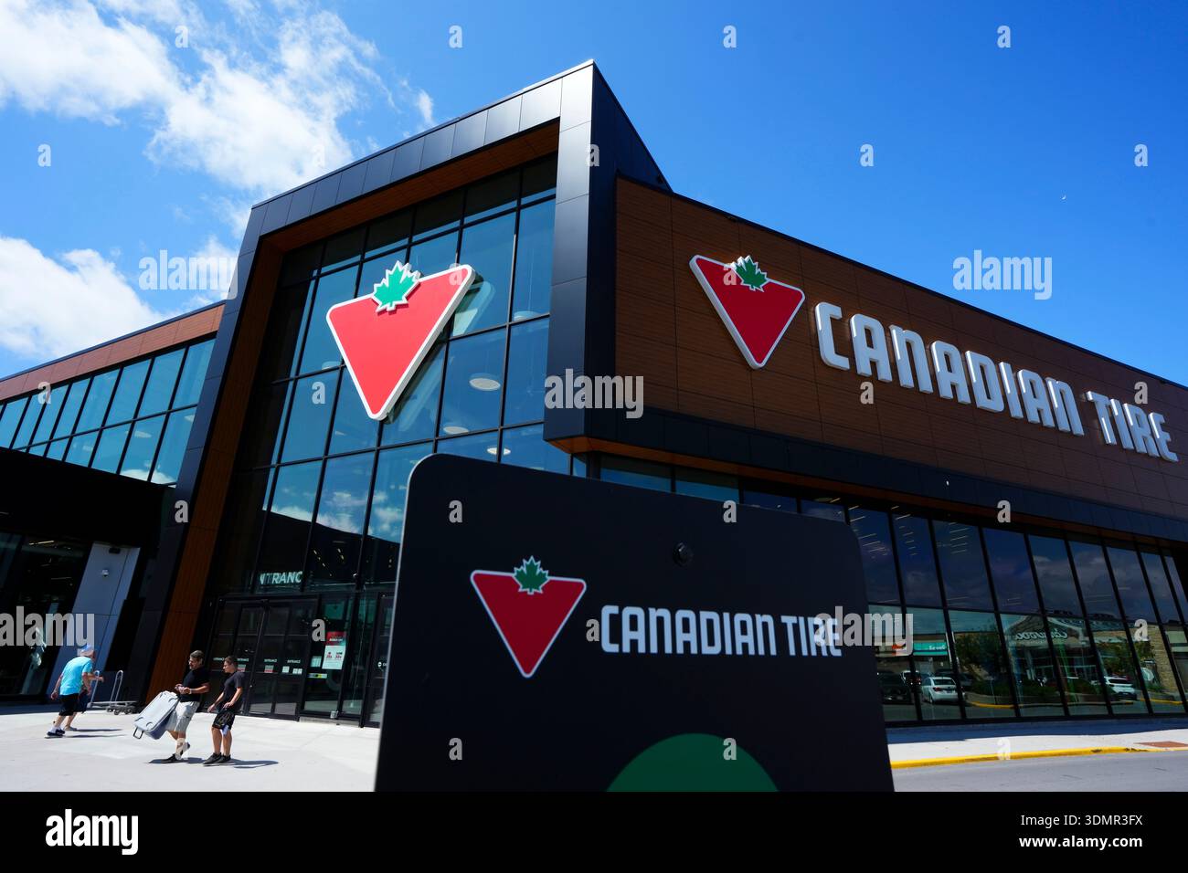 Des consommateurs vont et viennent dans une succursale de Canadian Tire ...