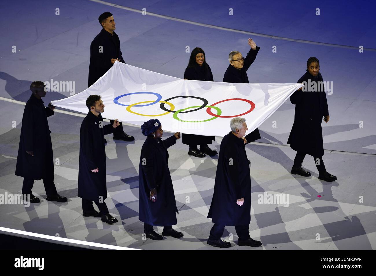 The Olympic flag is carried during the opening ceremony of the Milan ...