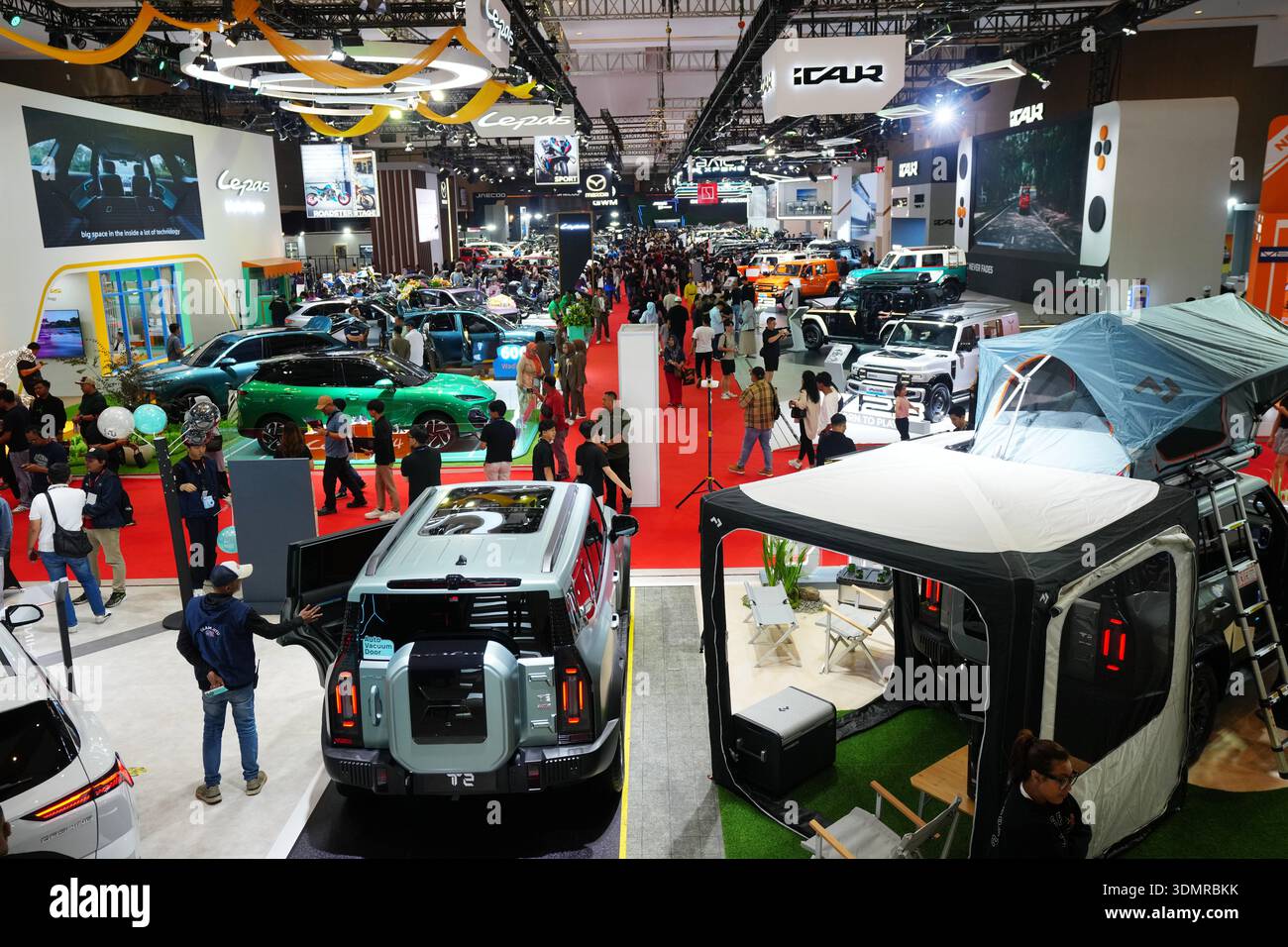 Visitors look at vehicles during the Indonesian International Motor ...