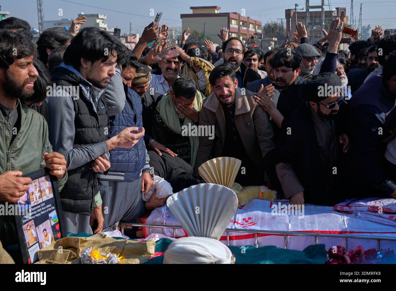 People mourn next the coffin of their relatives, killed in the Friday ...
