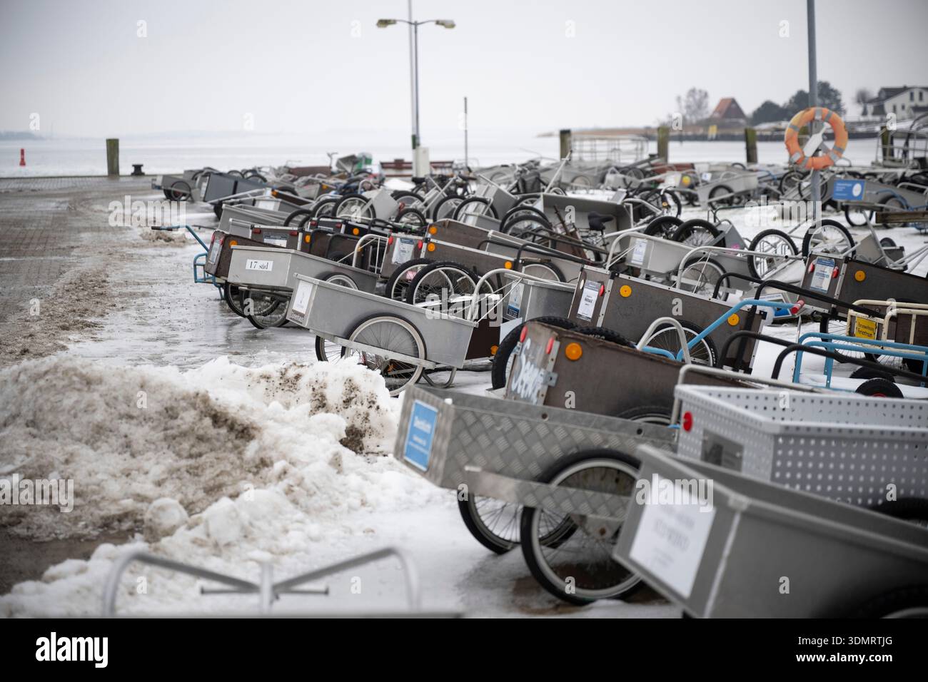 Vitte, Germany. 07th Feb, 2026. Handcarts stand in the ice in the port ...