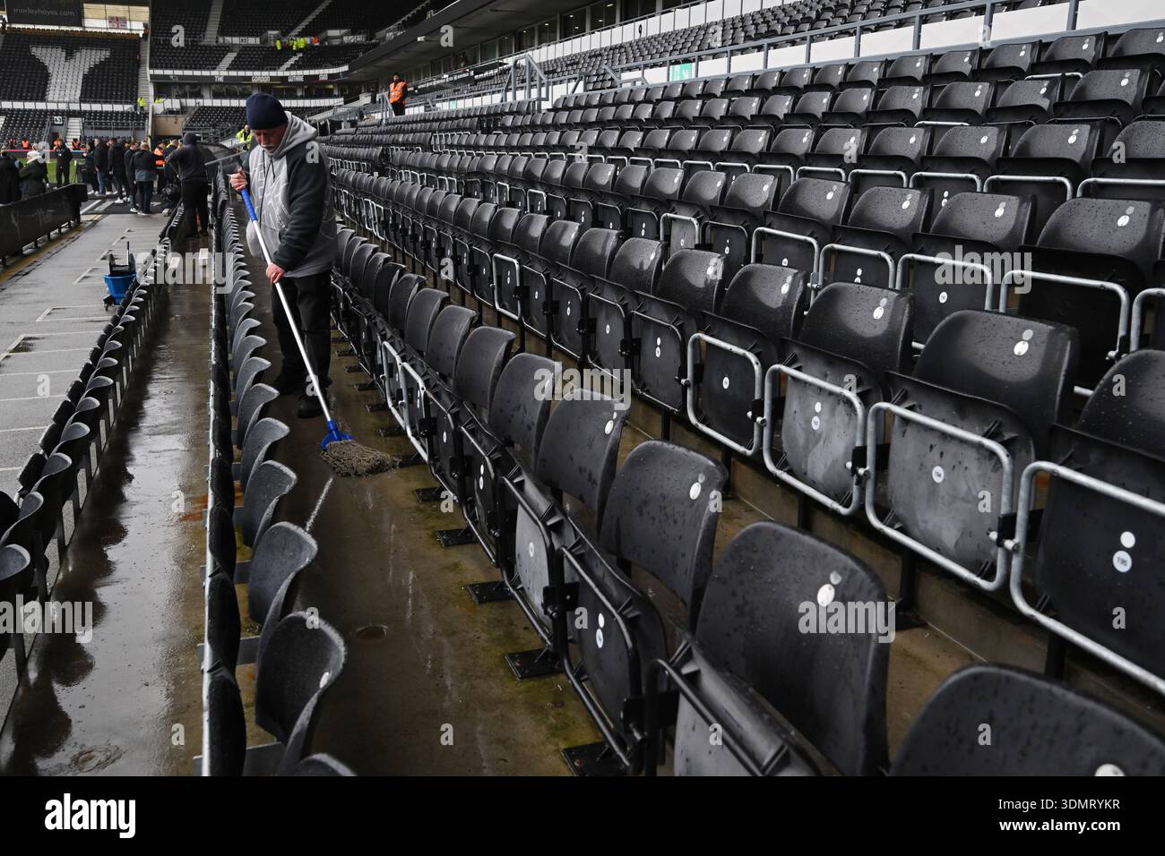 A member of staff getting rid of excess water from the stands ahead of ...
