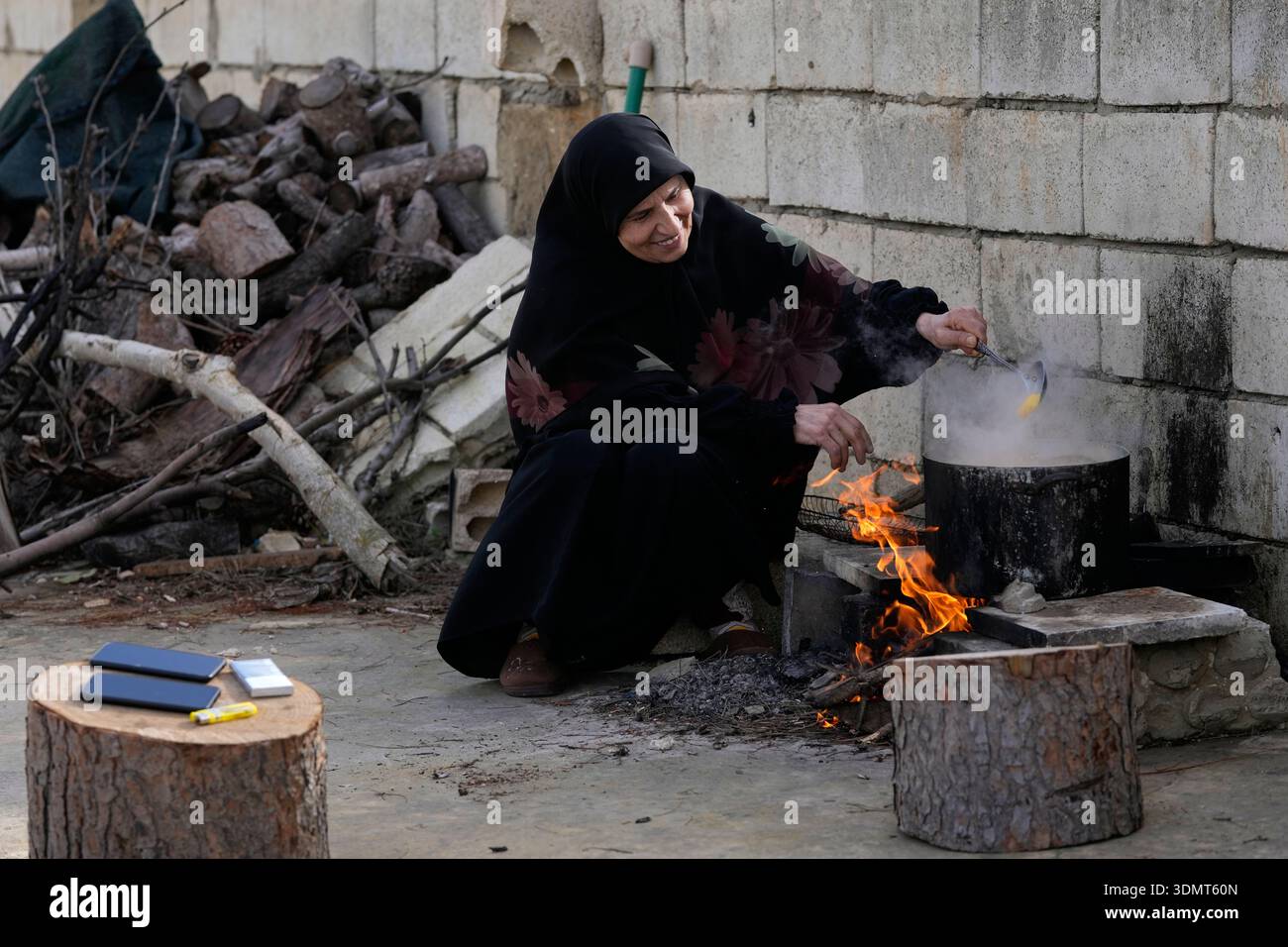 A woman cooks food in the village of Tayr Harfa, southern Lebanon ...