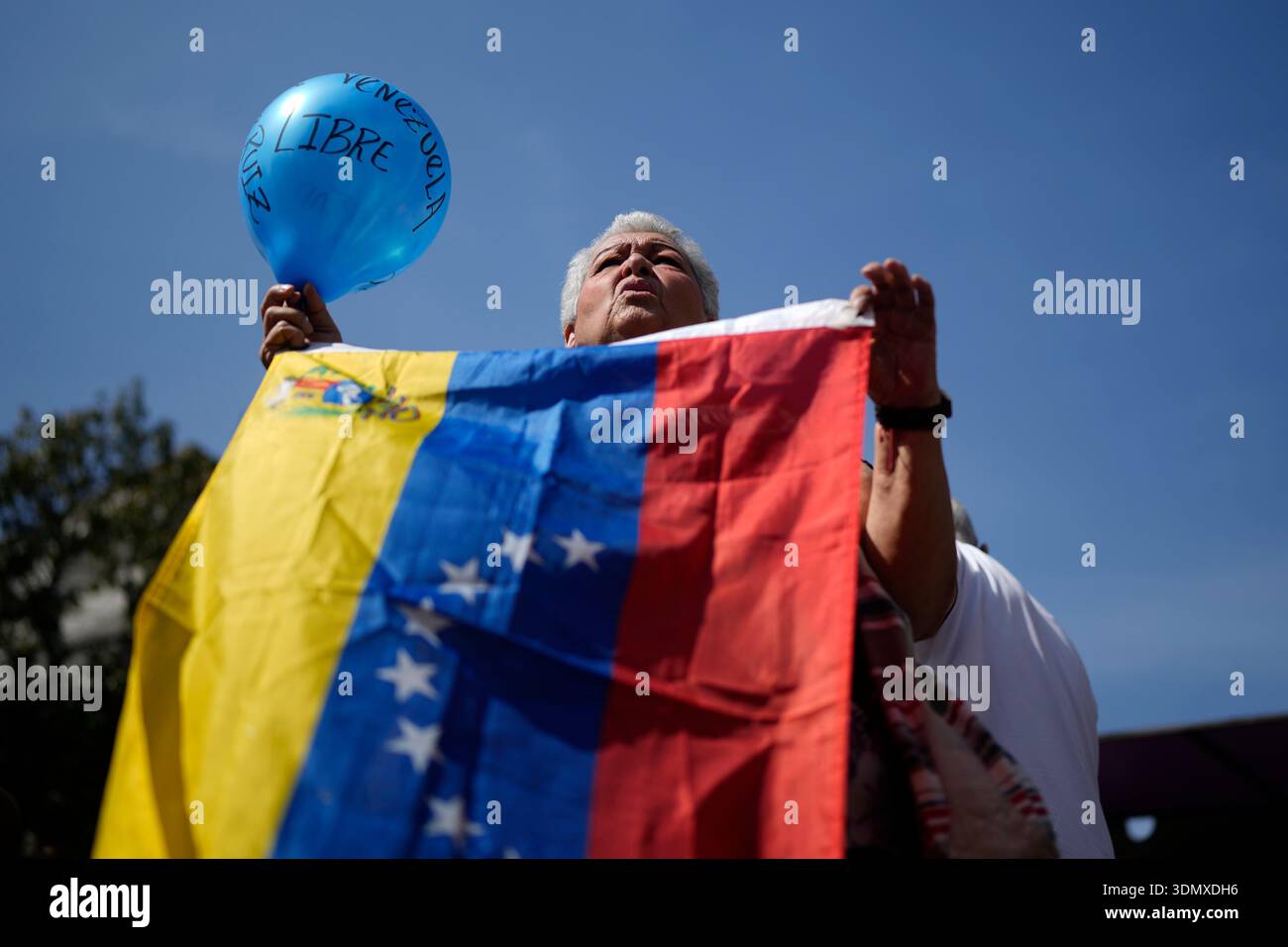 A woman holds a Venezuelan national flag during a prayer for freedom of ...