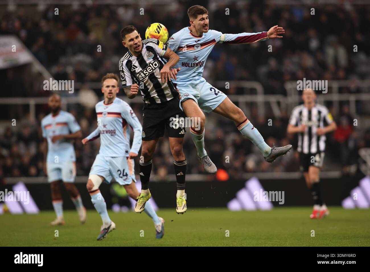 Vitaly Janelt of Brentford wins a header against Bruno Guimarães during ...