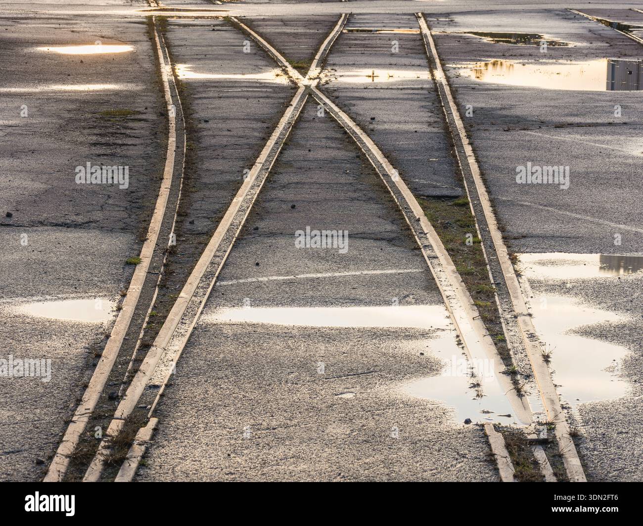 Railway tracks in Gothenburg sit on wet ground after rain. Puddles form ...