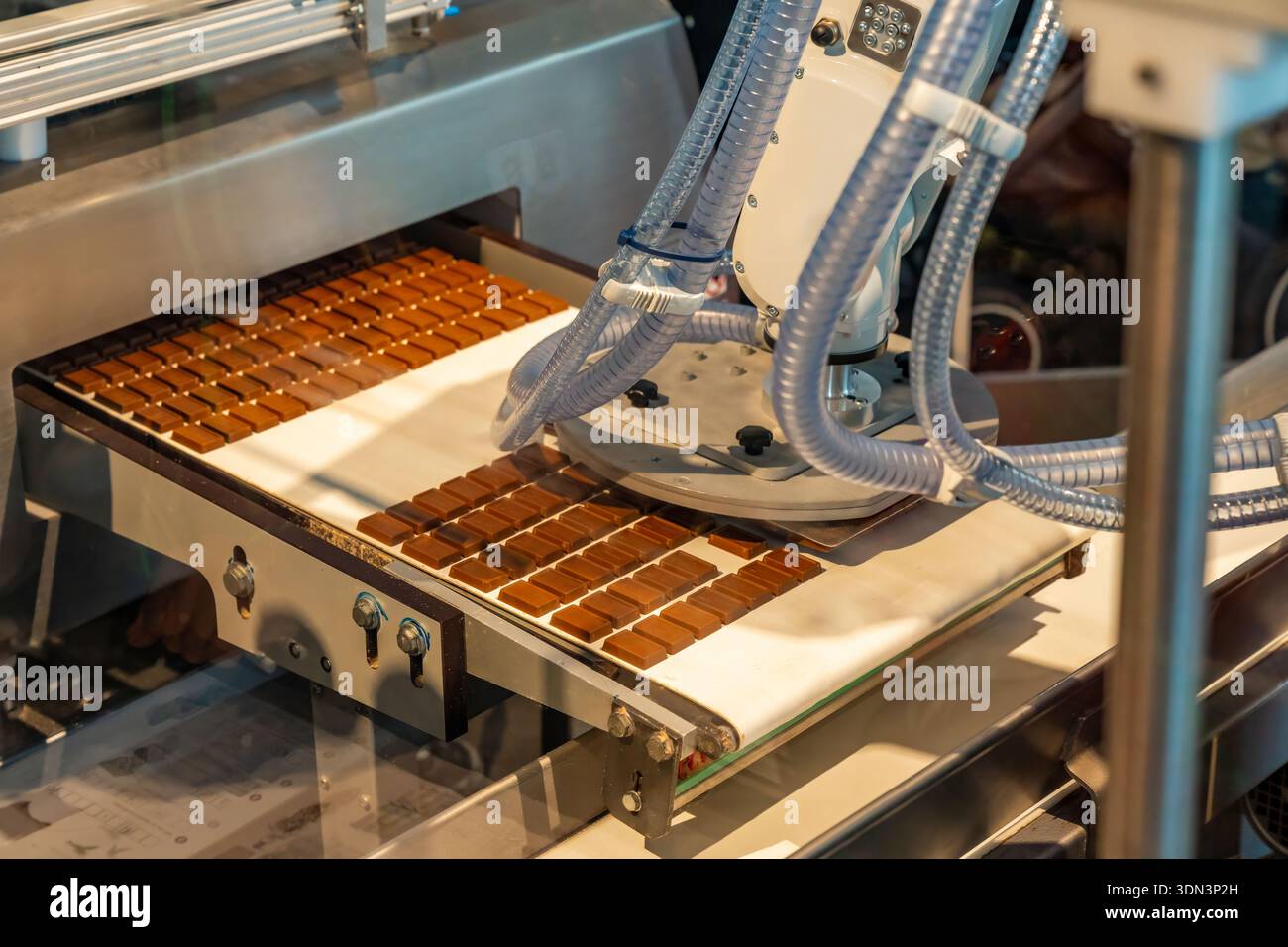 Automated system arranges candy bars. Robotic mechanisms and sensors ...