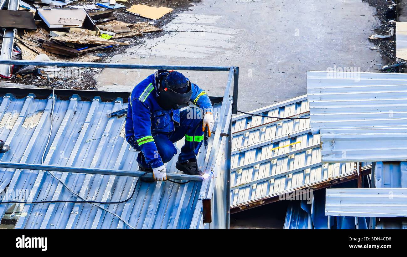A construction worker wearing a blue uniform, A construction worker ...