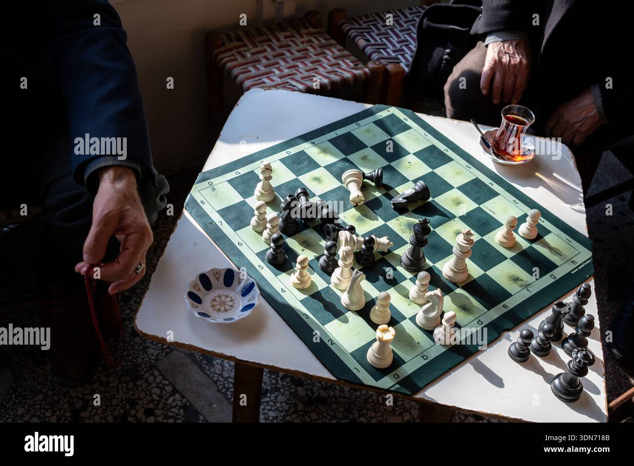 Two men drink tea after finishing a chess game in a coffeehouse in ...