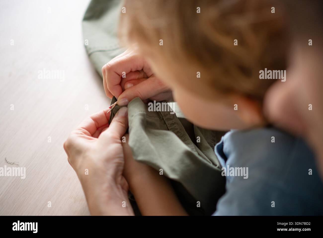 Woman sewing fixing cloth home hi-res stock photography and images - Alamy