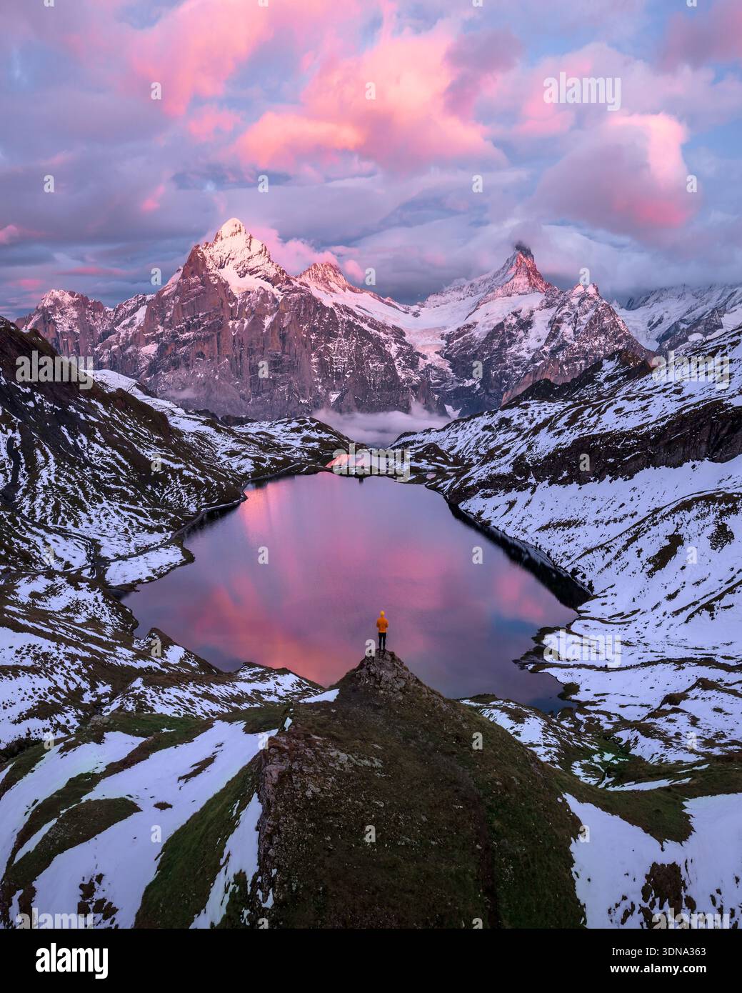 Aerial view of a solitary figure stands silhouetted against the mirror ...