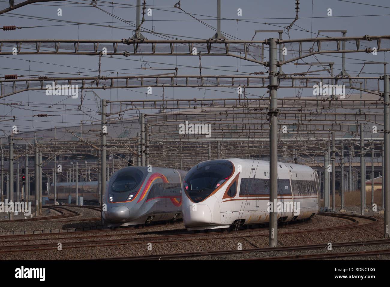 Two high-speed trains travel along parallel tracks in Beijing, China ...