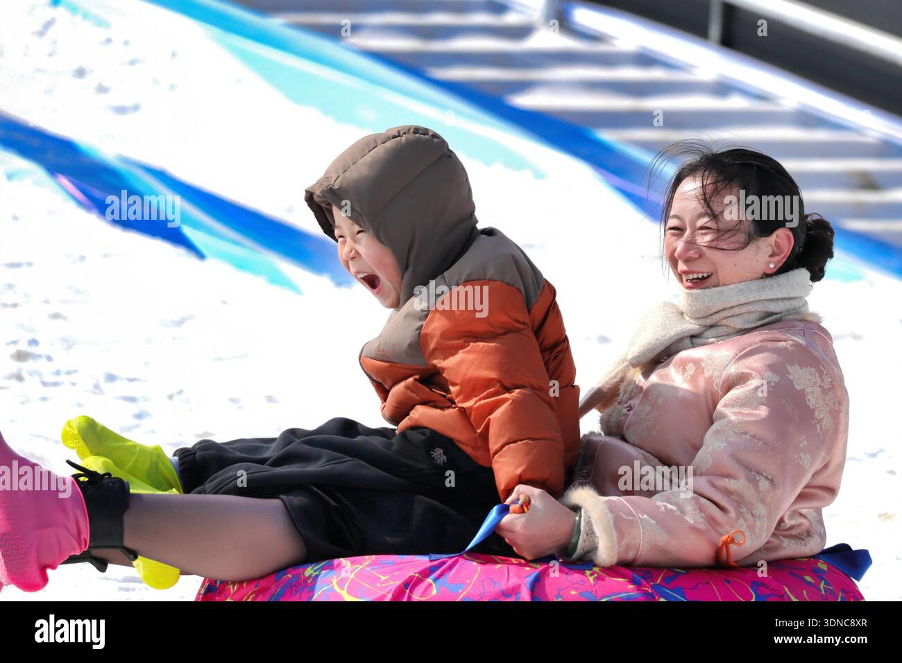 Children play with artificial snow at Jiulongkou National Wetland Park ...