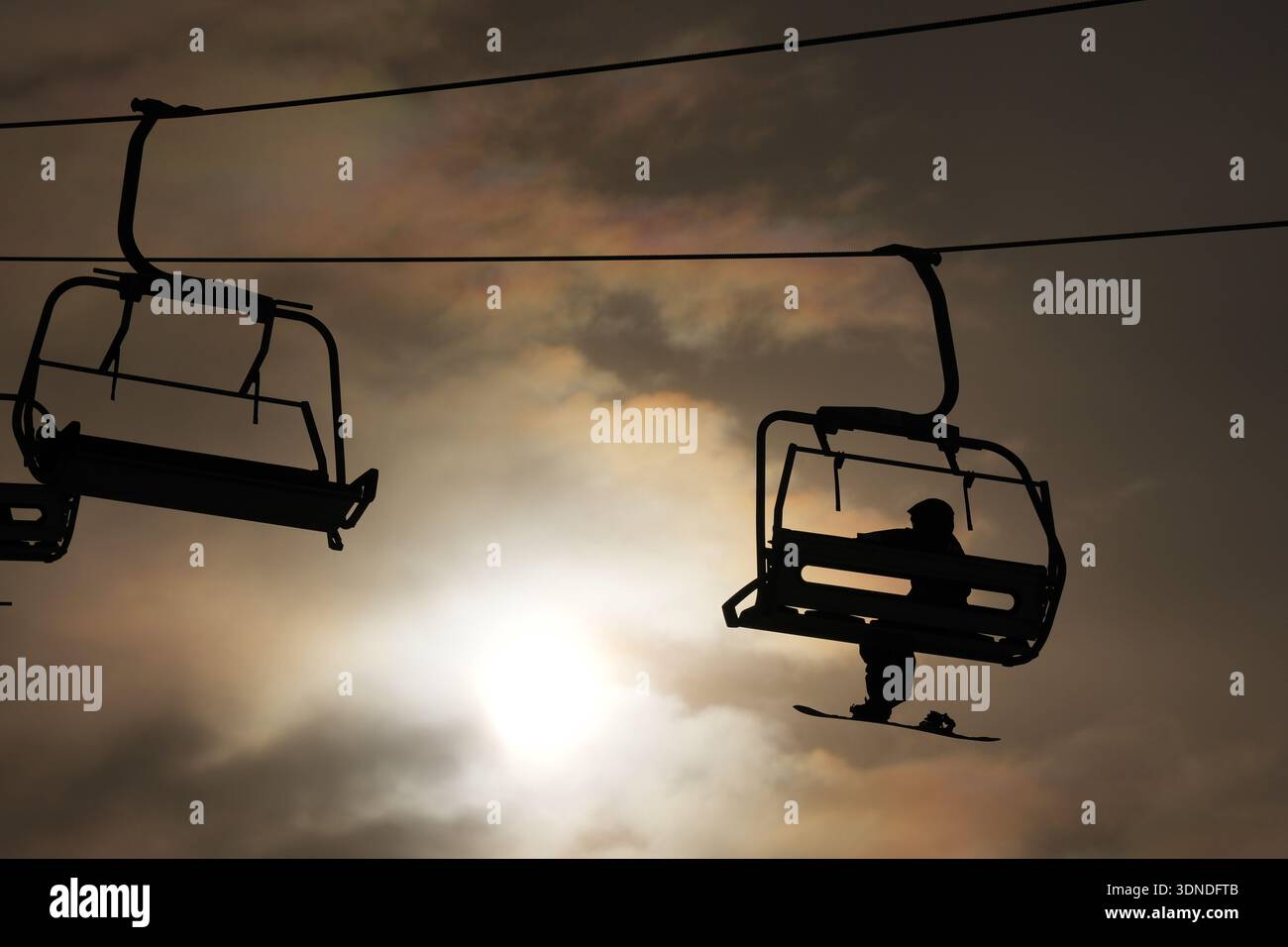 Athletes ride a chair lift during a snowboarding halfpipe training ...