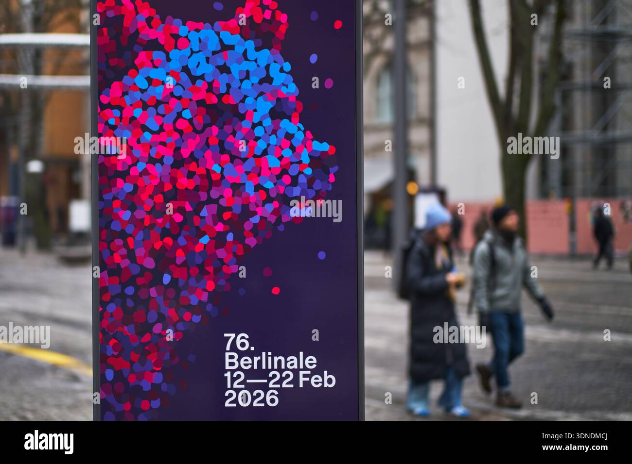 People walk past a Berlinale poster ahead of the International Film ...
