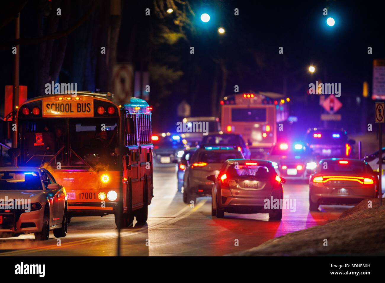 School buses and police cars drive on Wooton Parkway after a shooting ...