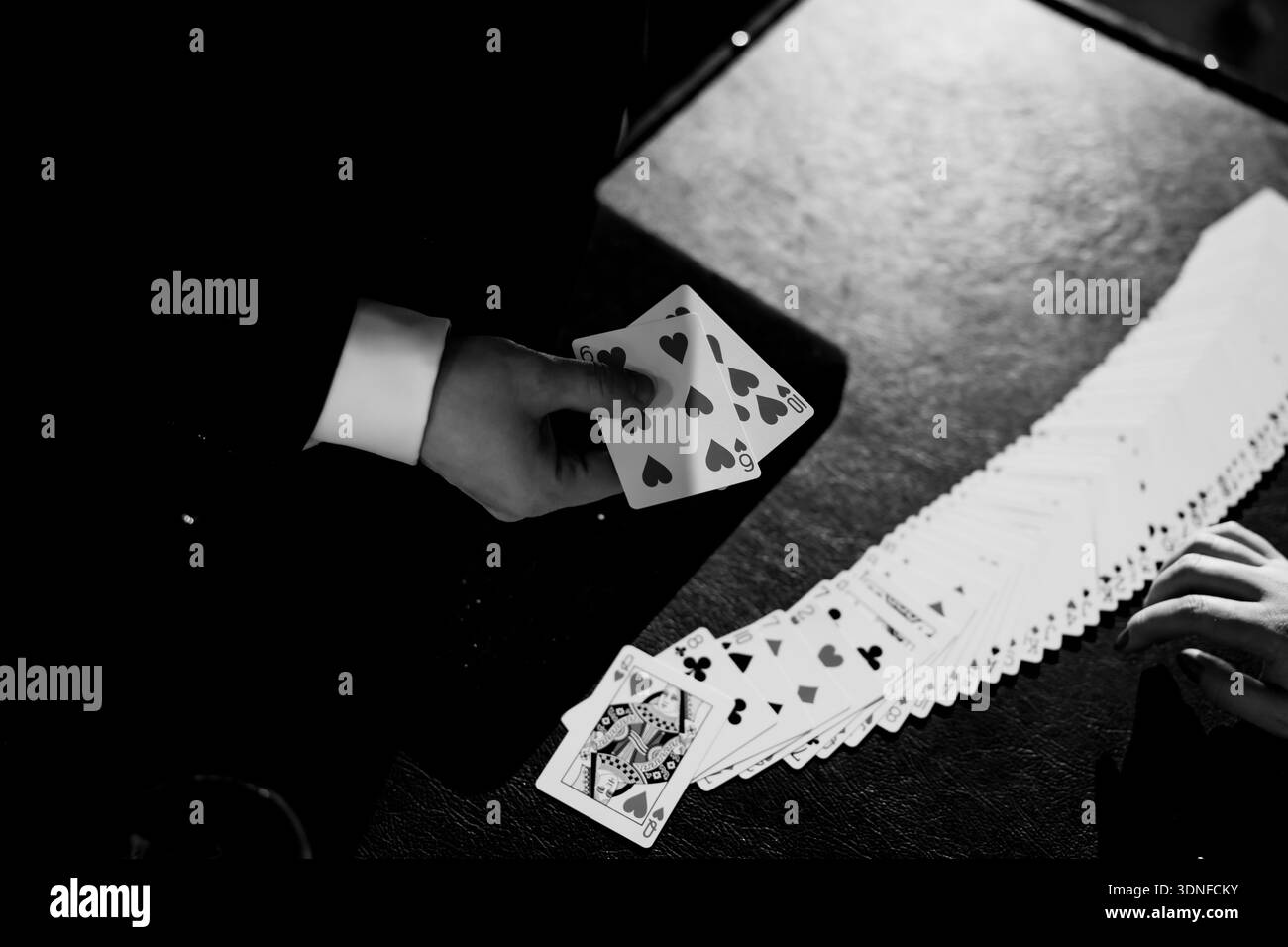High contrast black and white photo of sleight of hand card magic with ...