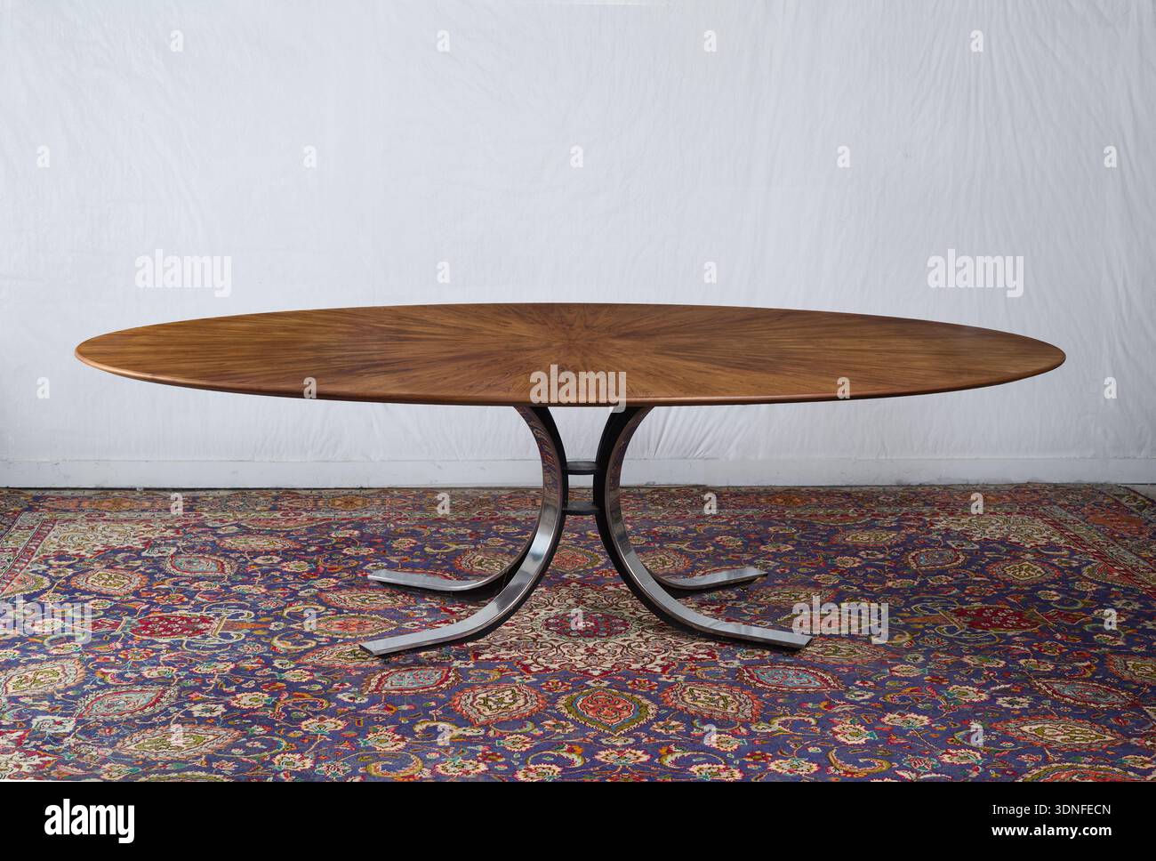 Dramatic rosewood oval dining table with chrome sleigh legs Stock Photo ...