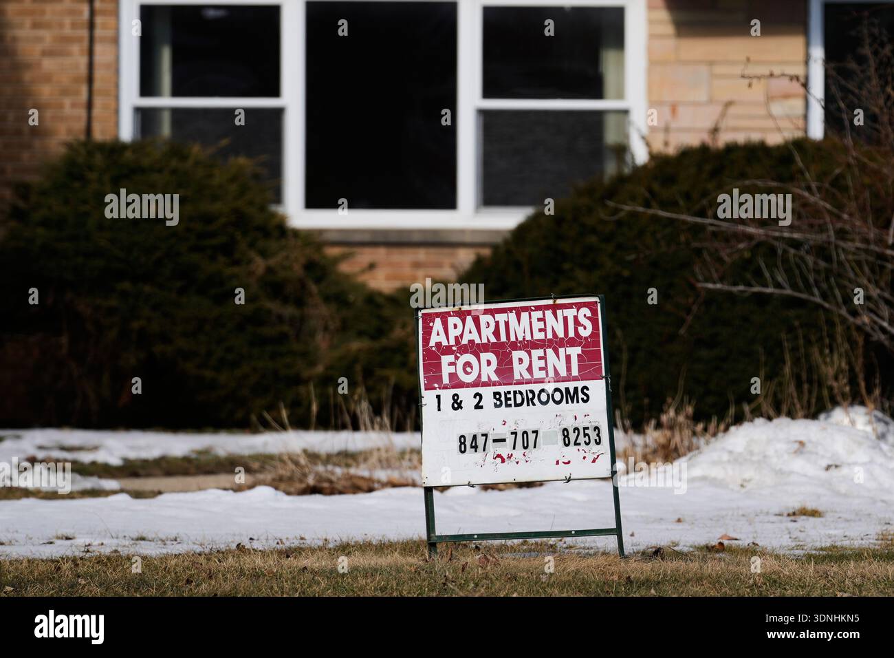 An "Apartments For Rent" sign is displayed outside an apartment ...