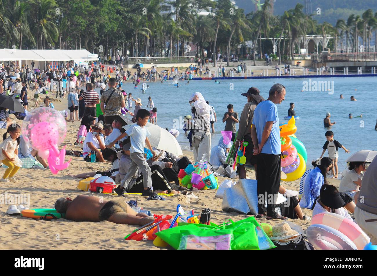 Tourists enjoy vacation on beach at Sanya Bay scenic area in Sanya City ...