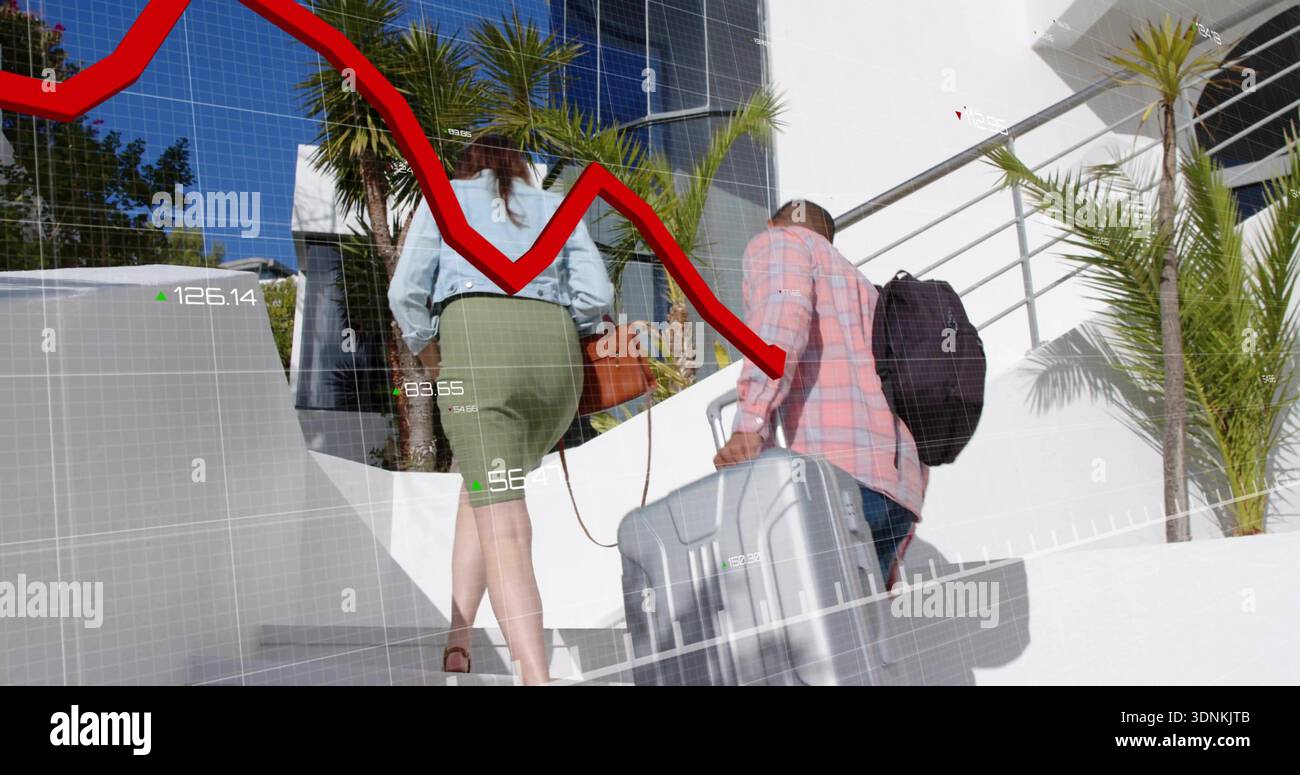 Walking women ascending stairs by glass facade, pulling silver suitcase ...