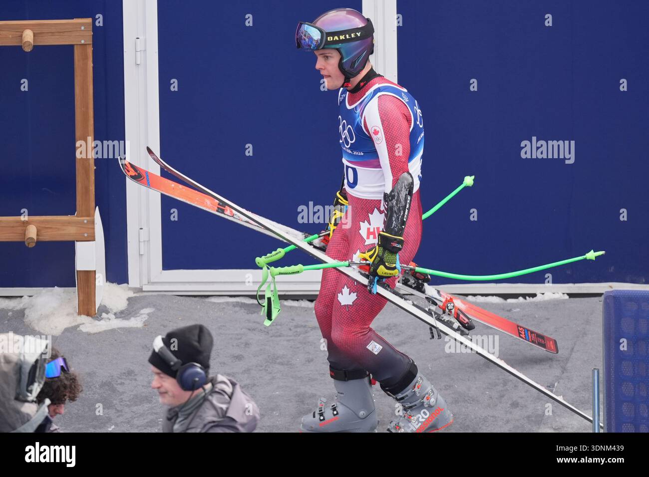 Canada's Riley Seger carries his skis after failing to complete an ...