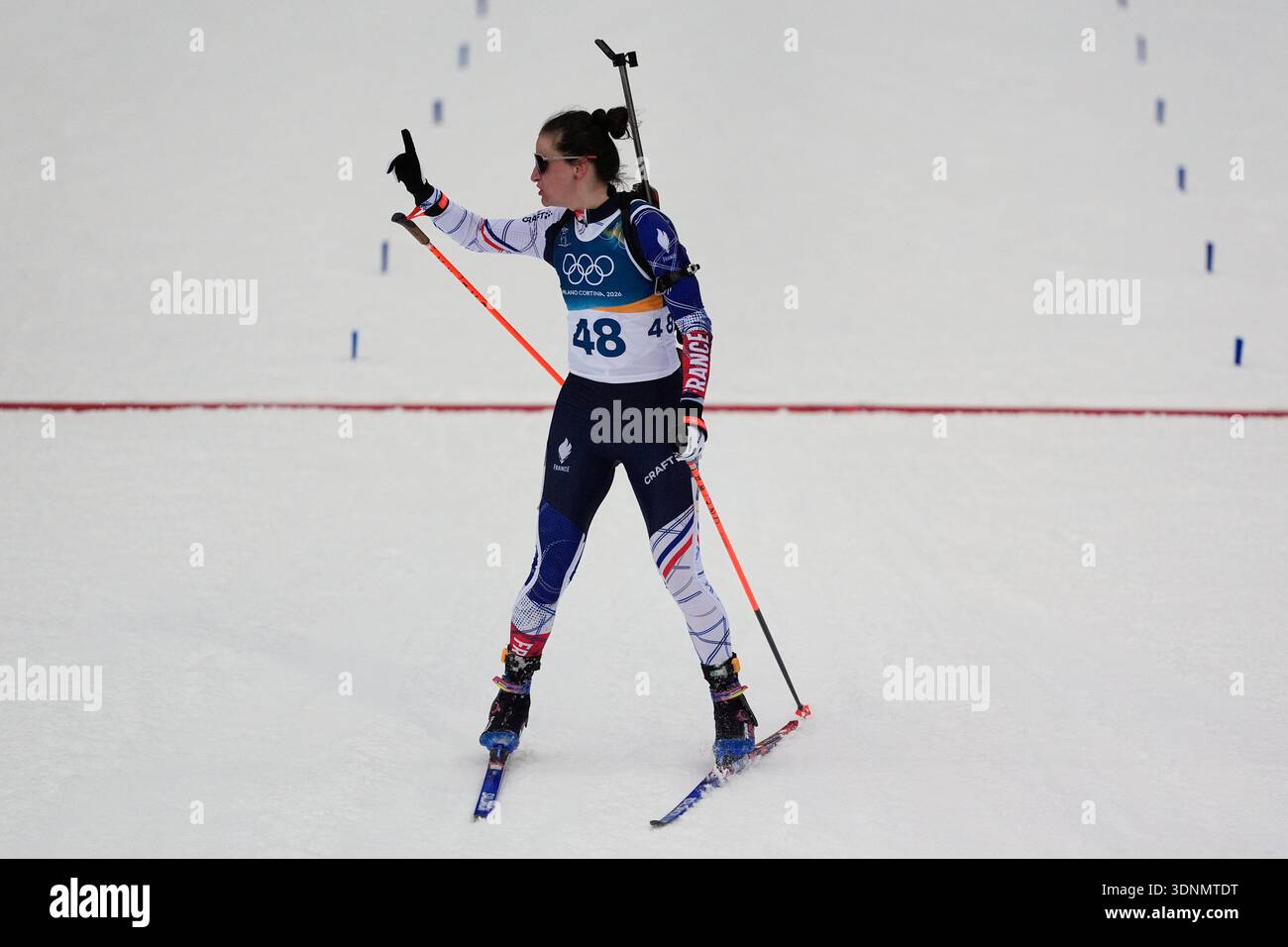 Julia Simon, of France, gestures after crossing the finish line in the ...