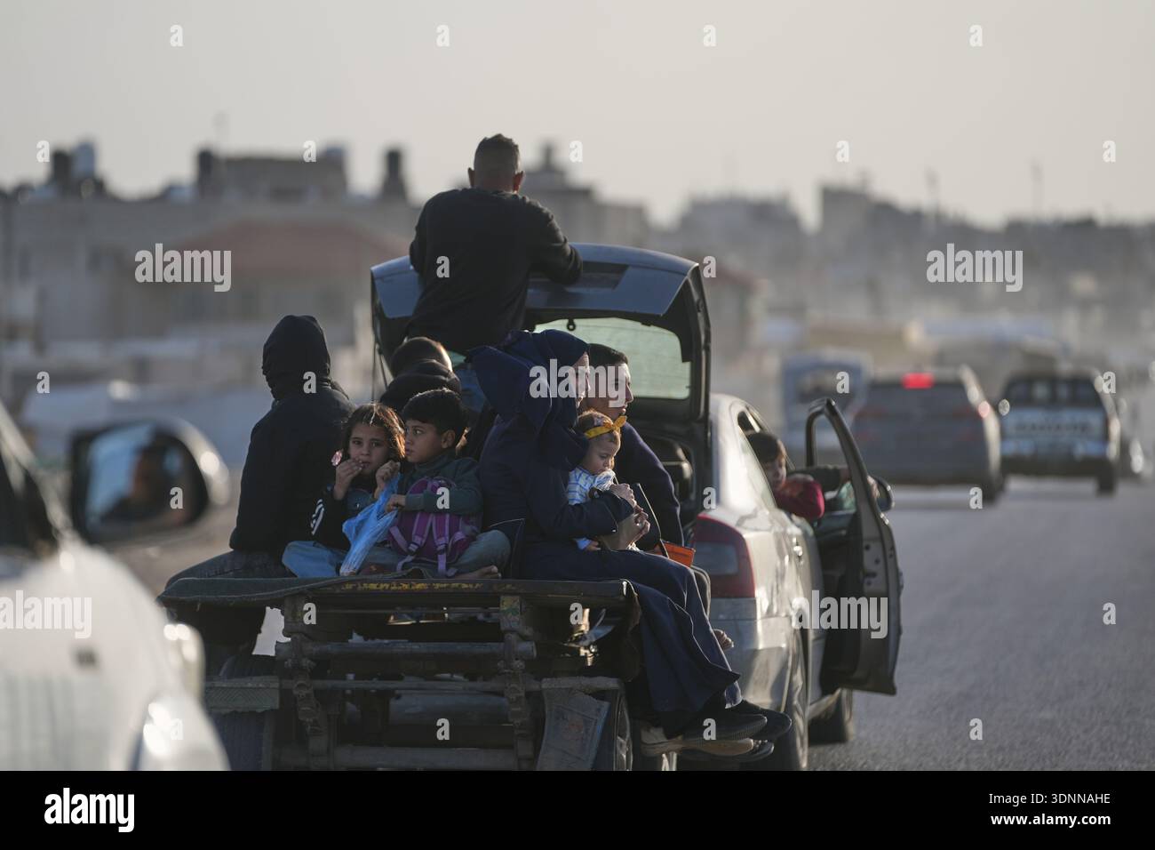 Palestinians travel on a cart attached to a car along the coastal road ...