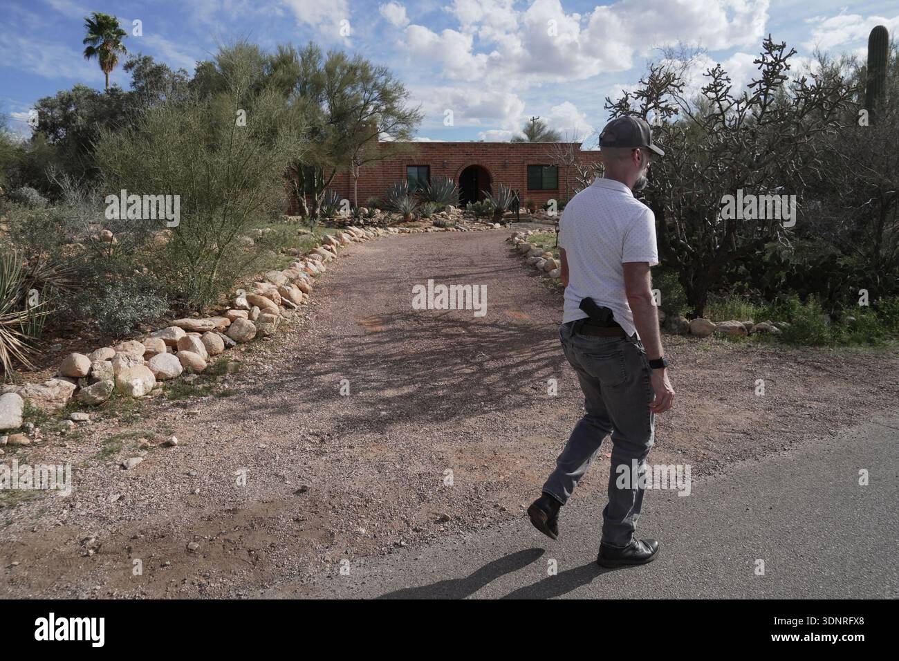 A law enforcement agent checks vegetation areas around Nancy Guthrie's ...