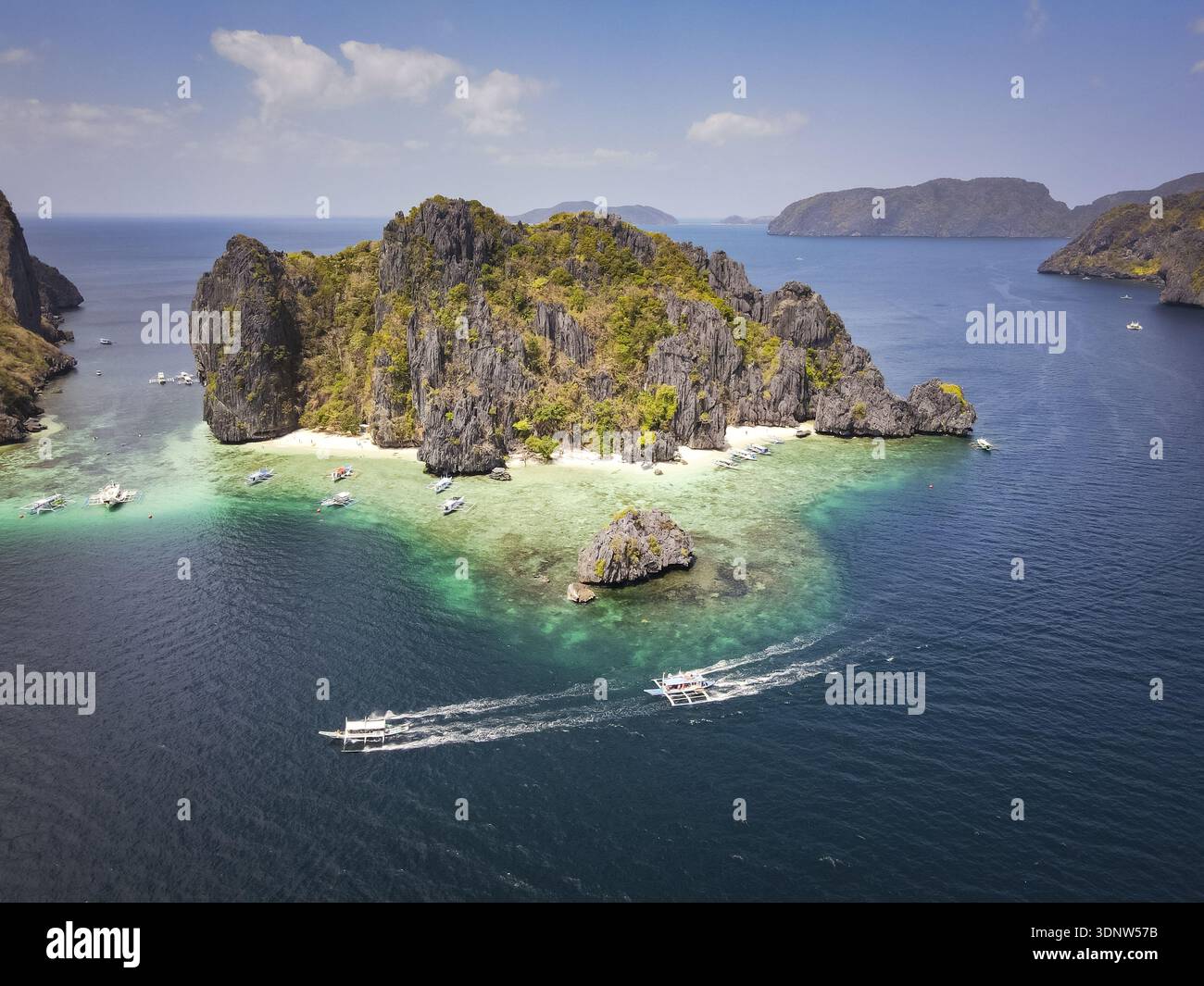 Aerial view of boats cutting through the turquoise sea towards a ...