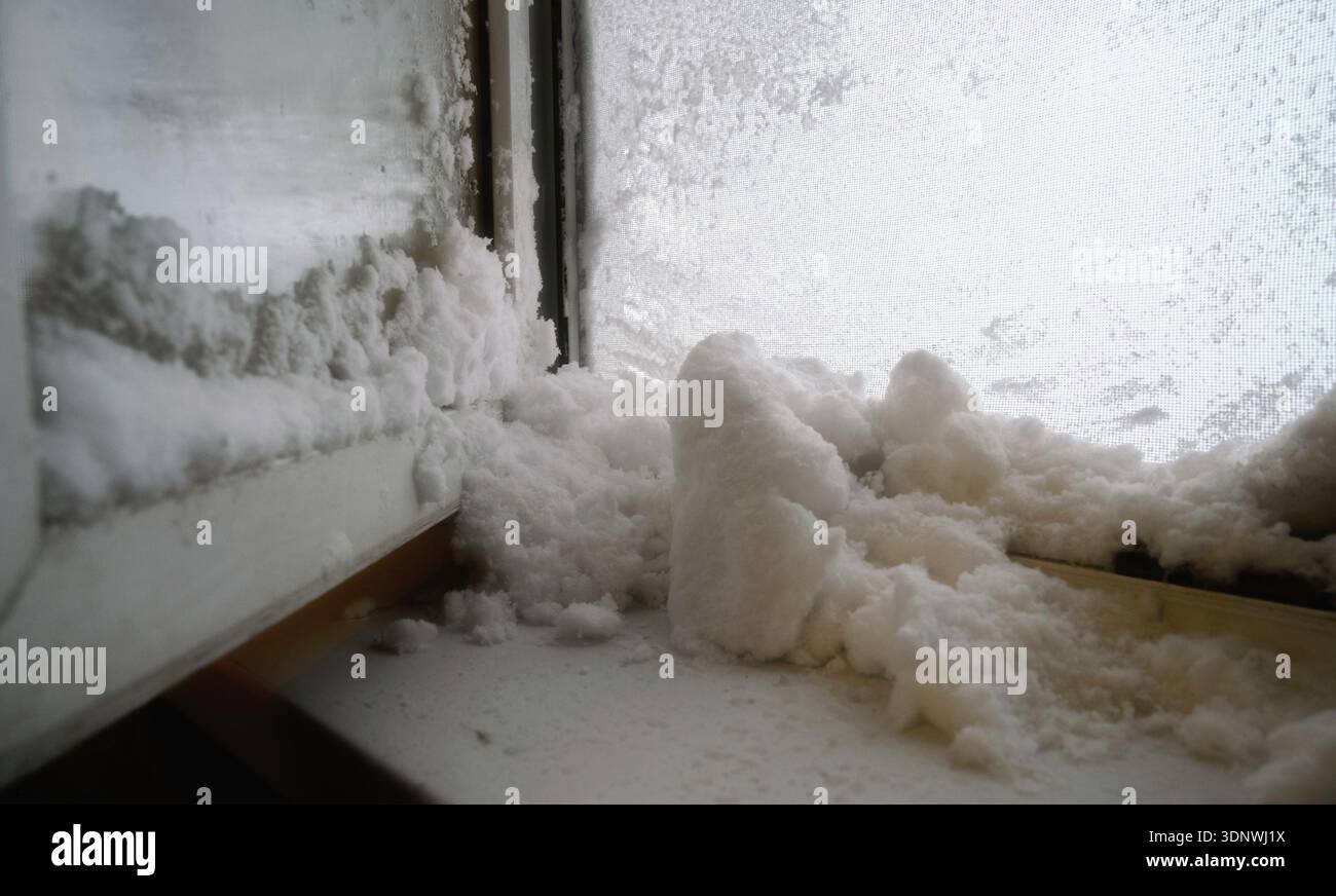 Snow piled on windowsill inside open window during winter storm Stock ...