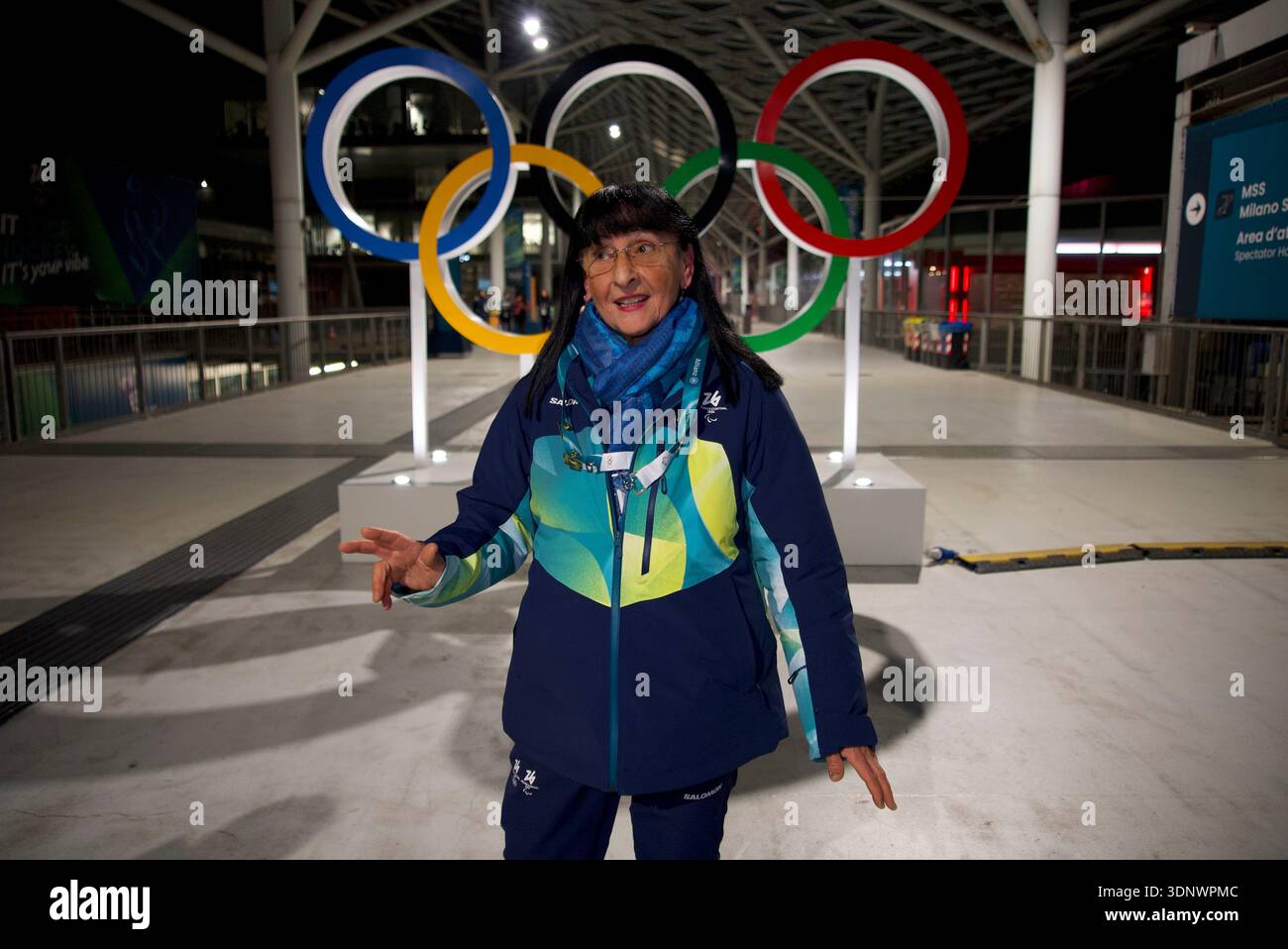 Angela Frisina, a volunteer at the 2026 Winter Olympics walks through ...