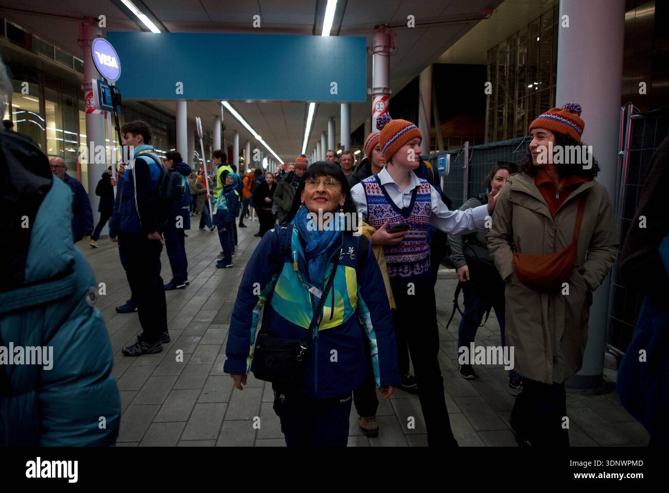 Angela Frisina, a volunteer at the 2026 Winter Olympics walks through ...