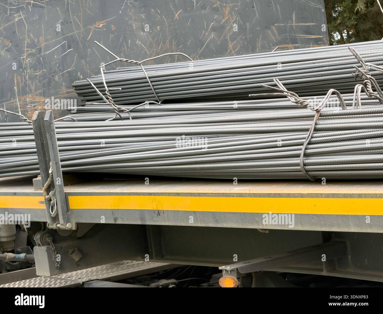Bundles of steel rebar are securely loaded on a flatbed truck, prepared ...
