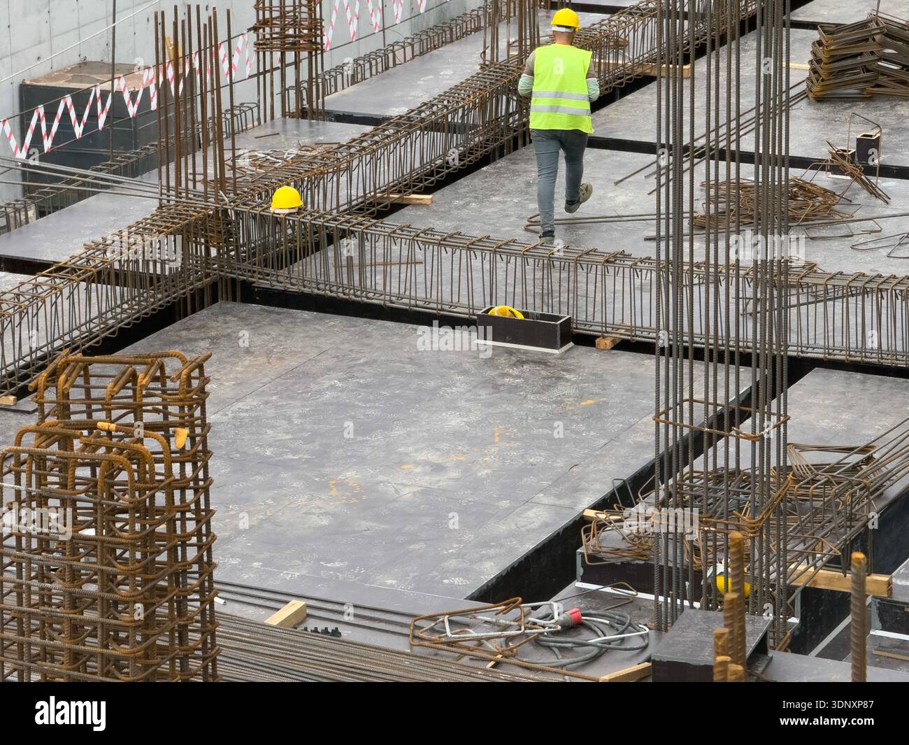A worker navigates the foundation and formwork system on a construction ...