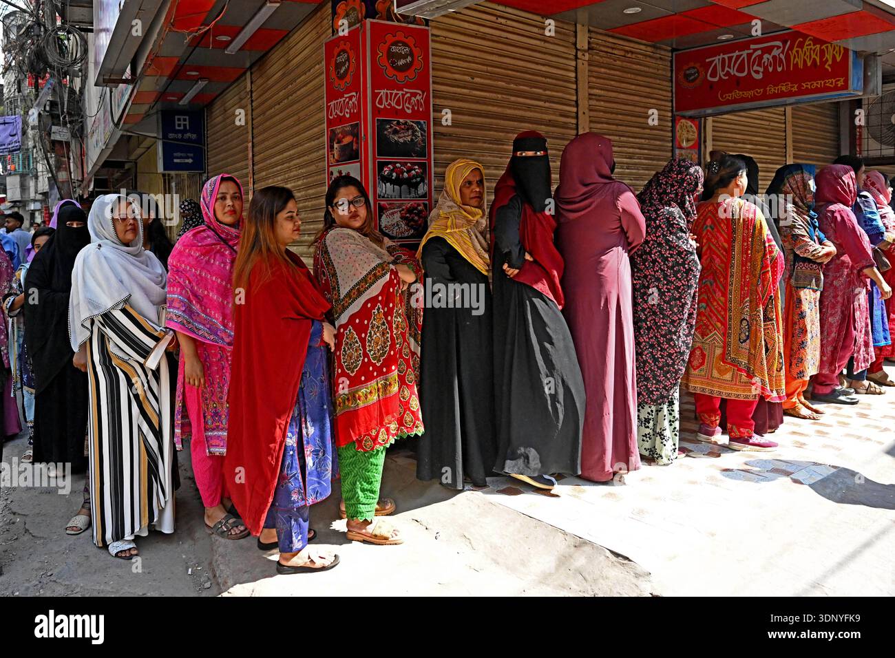 Women voters wait in a queue outside a polling station in the 13th ...