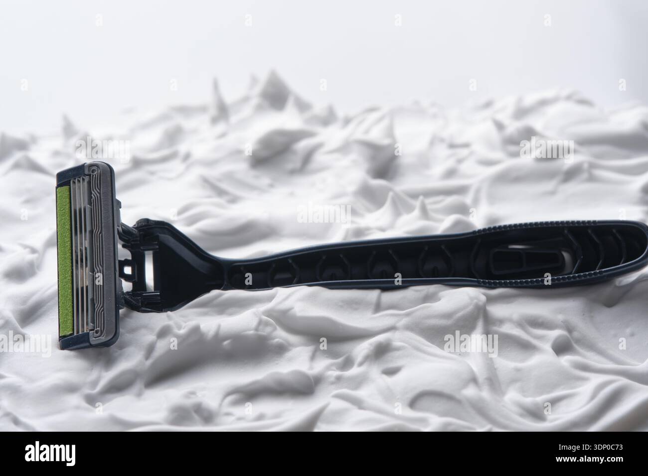 Razor with open blade architecture lying horizontally on surface of ...
