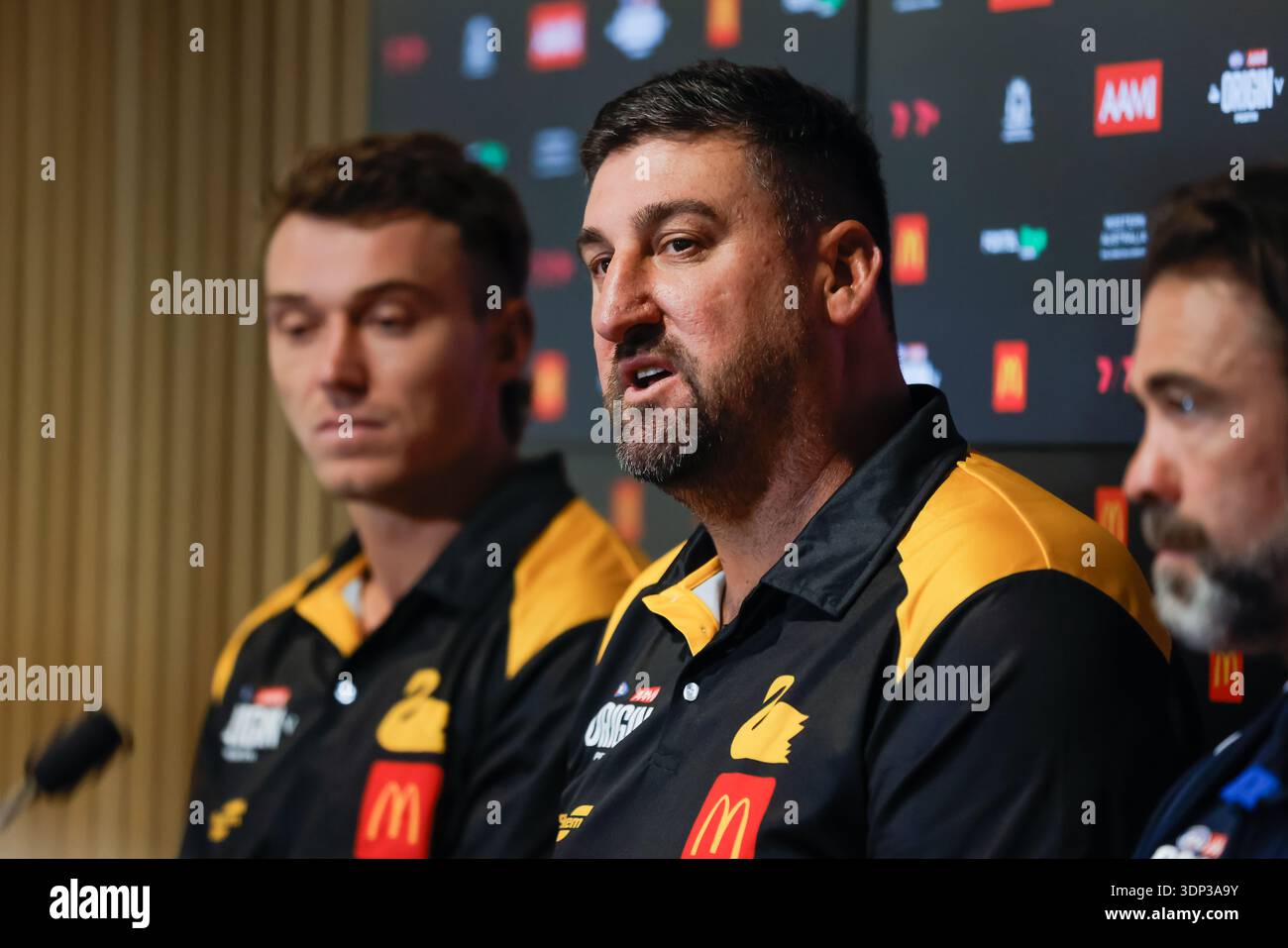 Western Australia coach Dean Cox speaks as captain Patrick Cripps looks ...