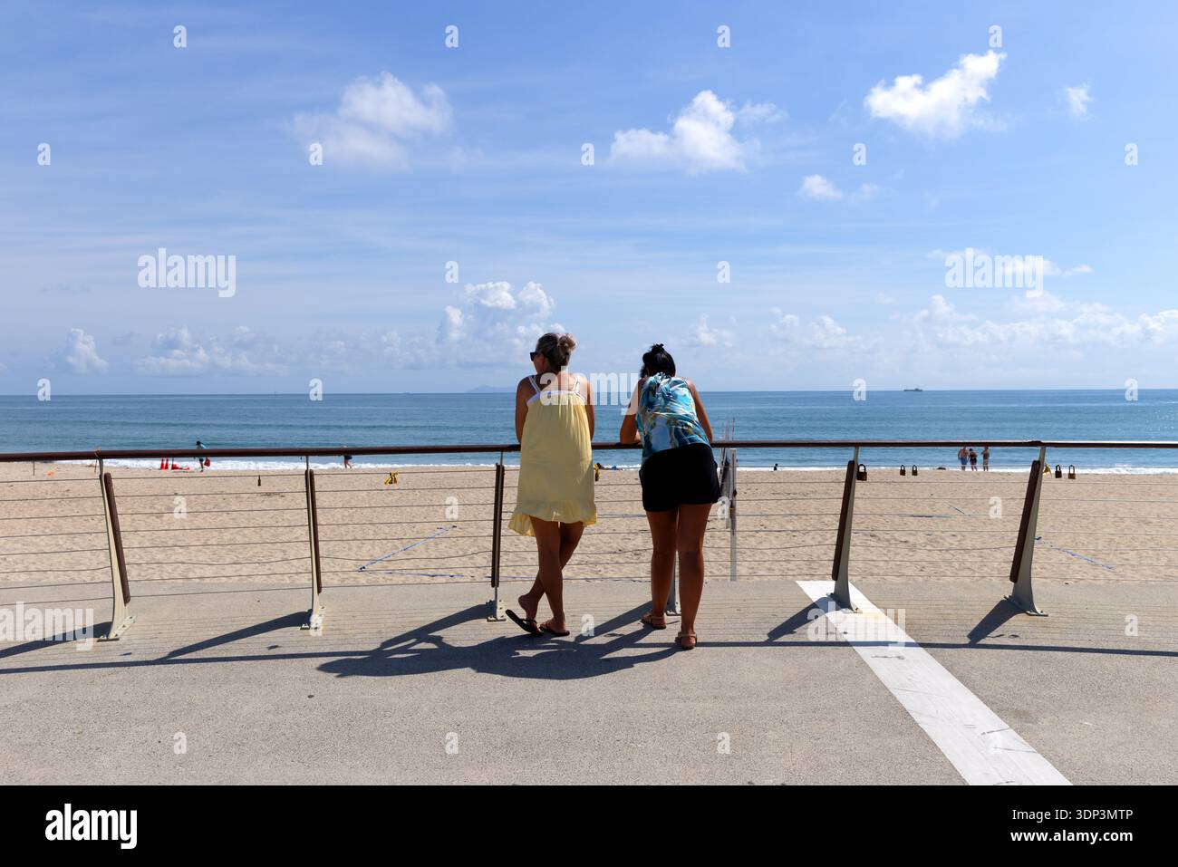 Two women looking out to sea from a beachfront promenade at Mount ...