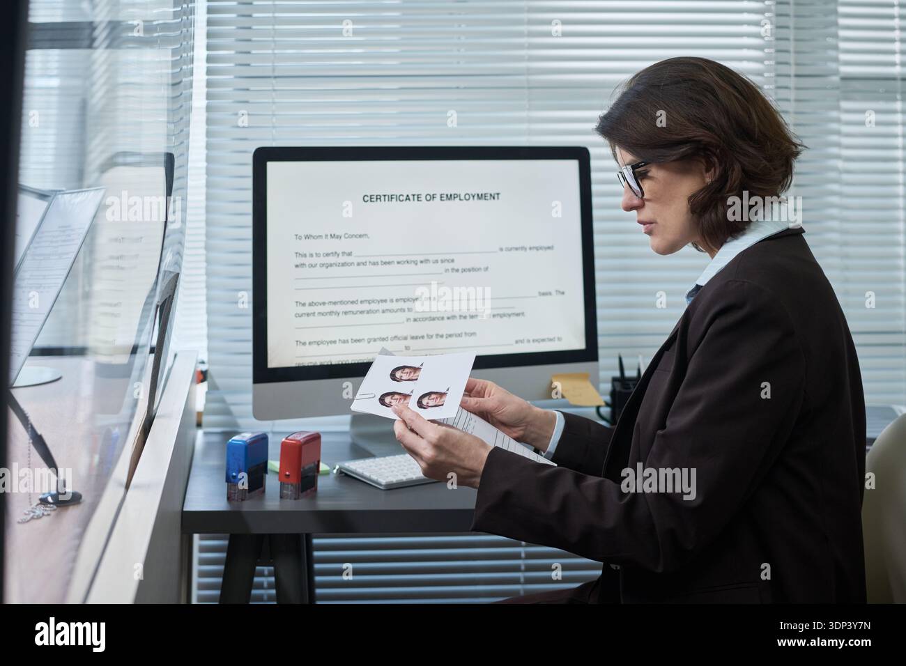 Middle aged Caucasian woman sitting at visa center desk examining ...