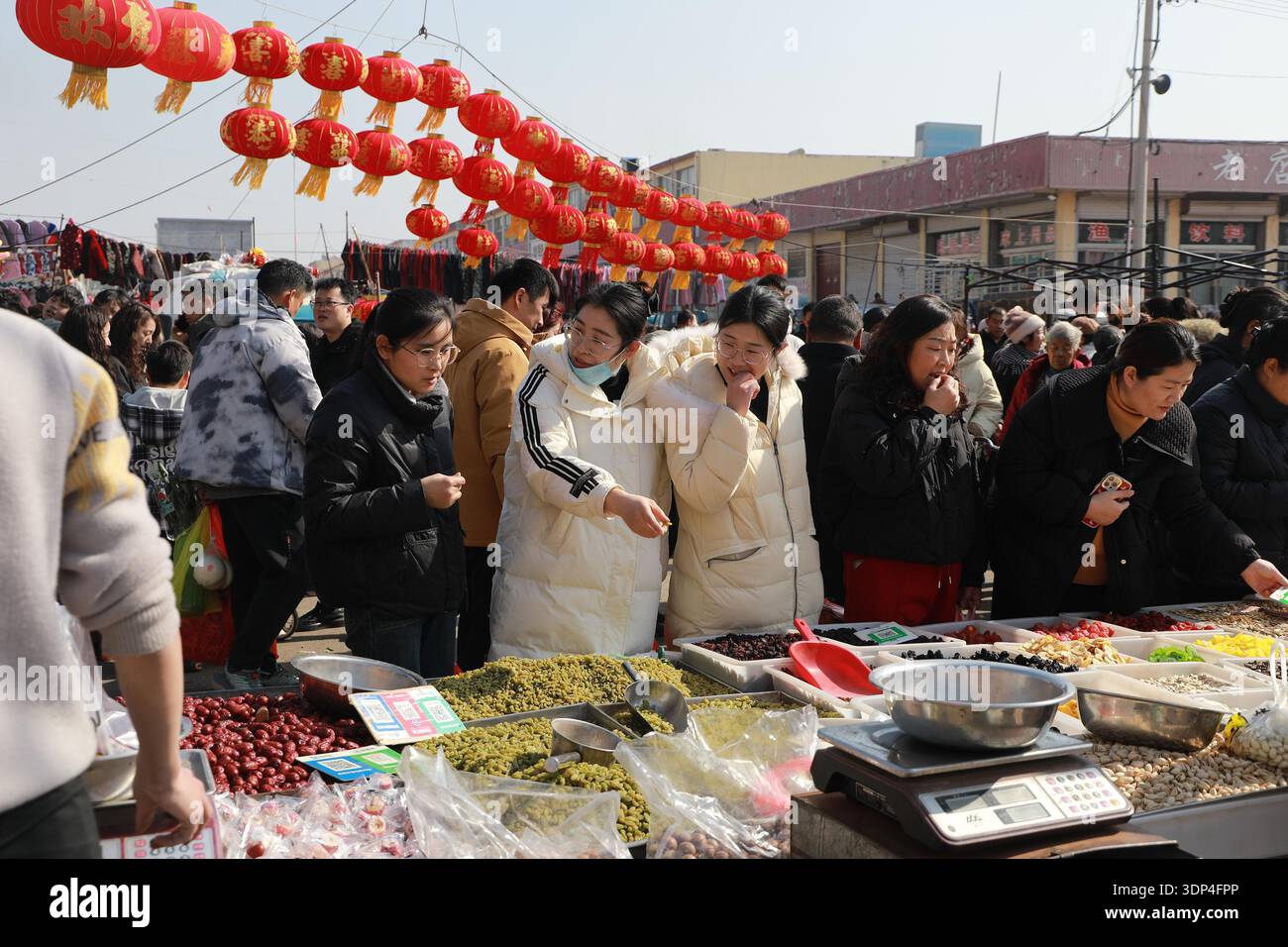 People shop for New Year goods at a Spring Festival market in Shanting ...