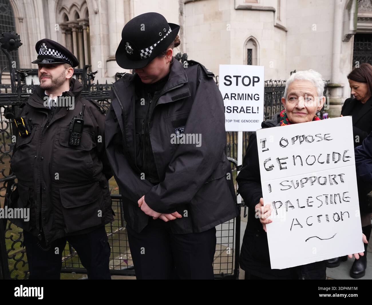 Police officers stand beside protesters outside the High Court, central ...