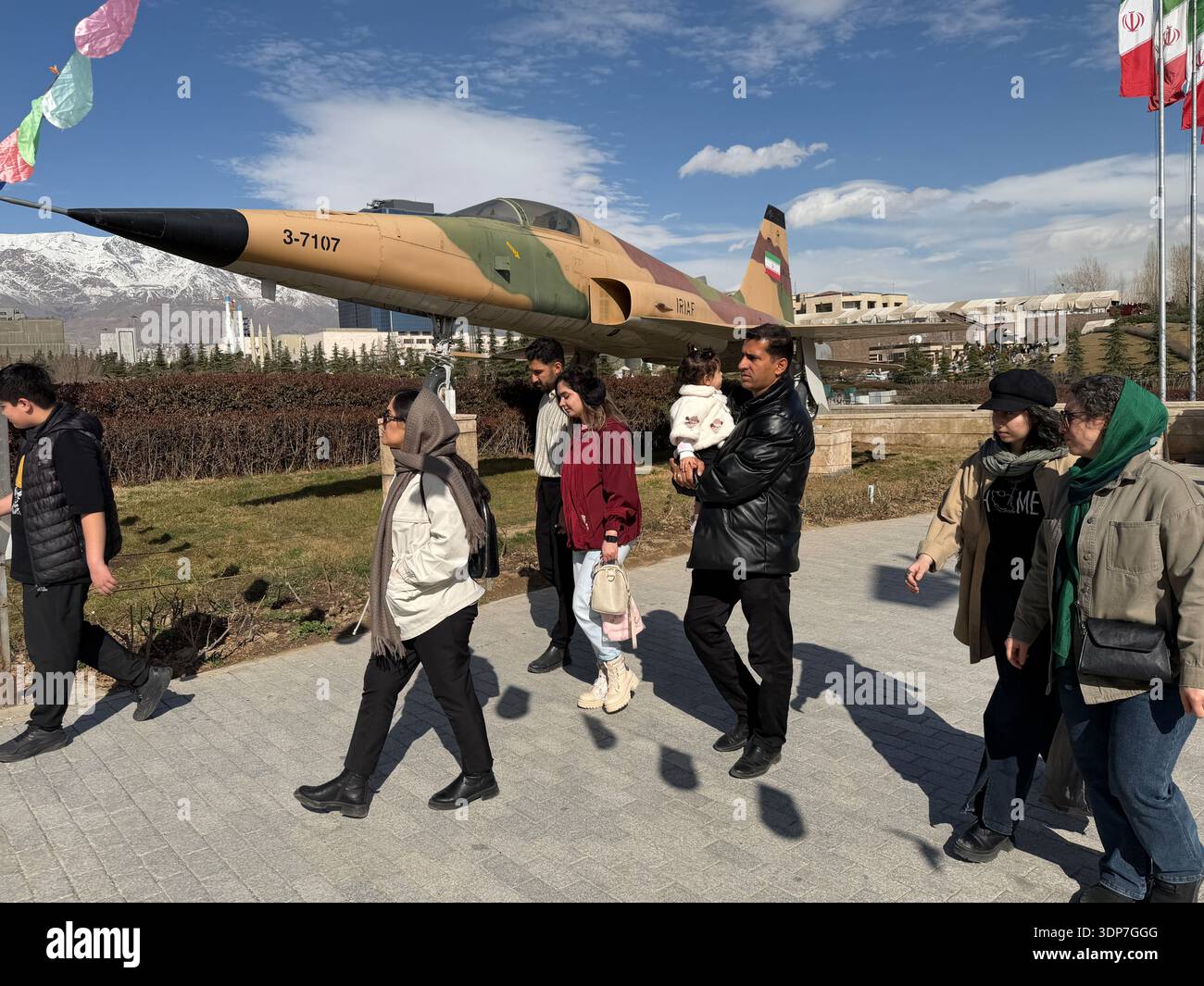 People walk past a U.S. made F-5 Tiger jet of the Iranian air force ...