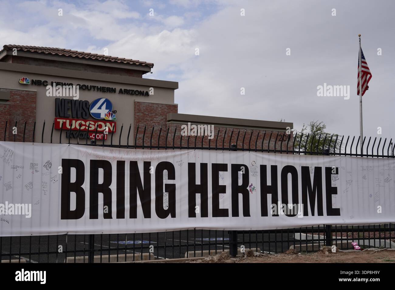 A banner reading "Bring her home" on a fence outside of the KVOA news ...