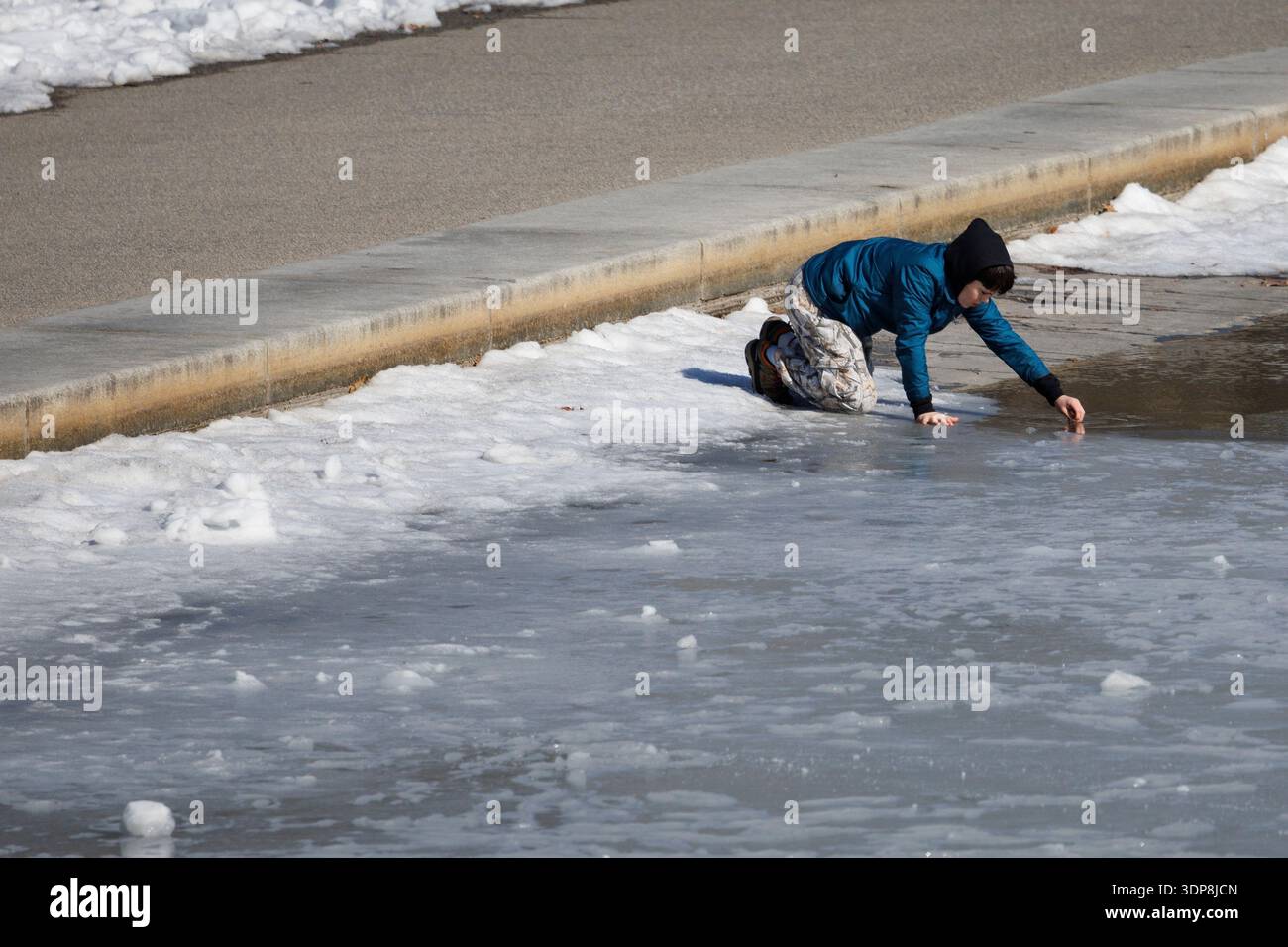 Jonah Cooper, of Chicago, dips his hand in the waters of the Reflecting ...