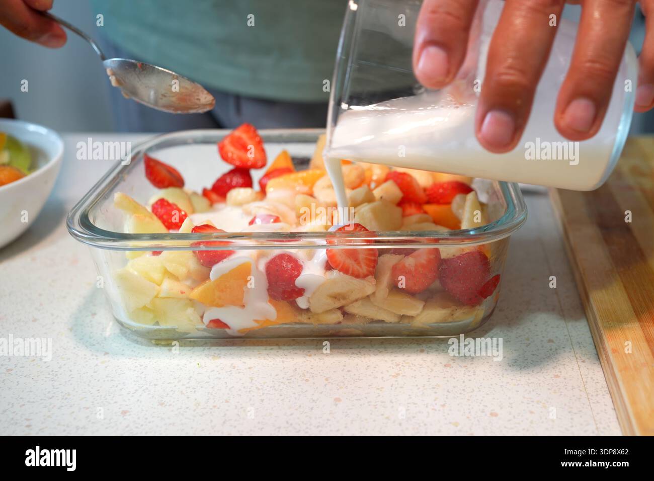 Person pouring milk over fresh fruit. Milk being poured onto colorful ...