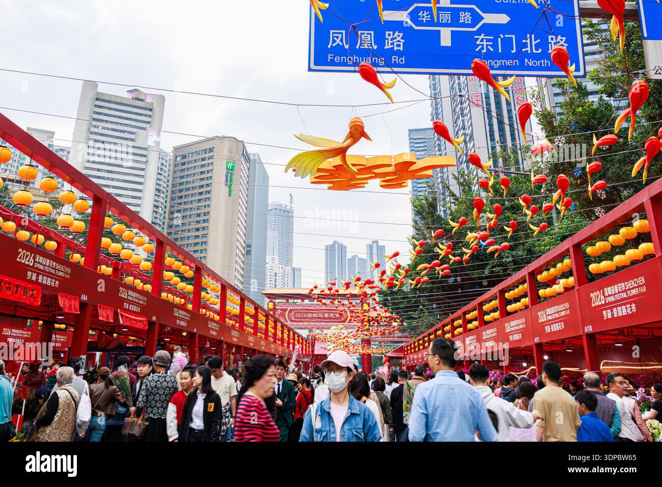 Visitors browse stalls decorated with red lanterns at the Aiguo Road ...