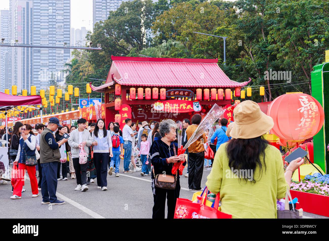 Visitors browse stalls decorated with red lanterns at the Aiguo Road ...